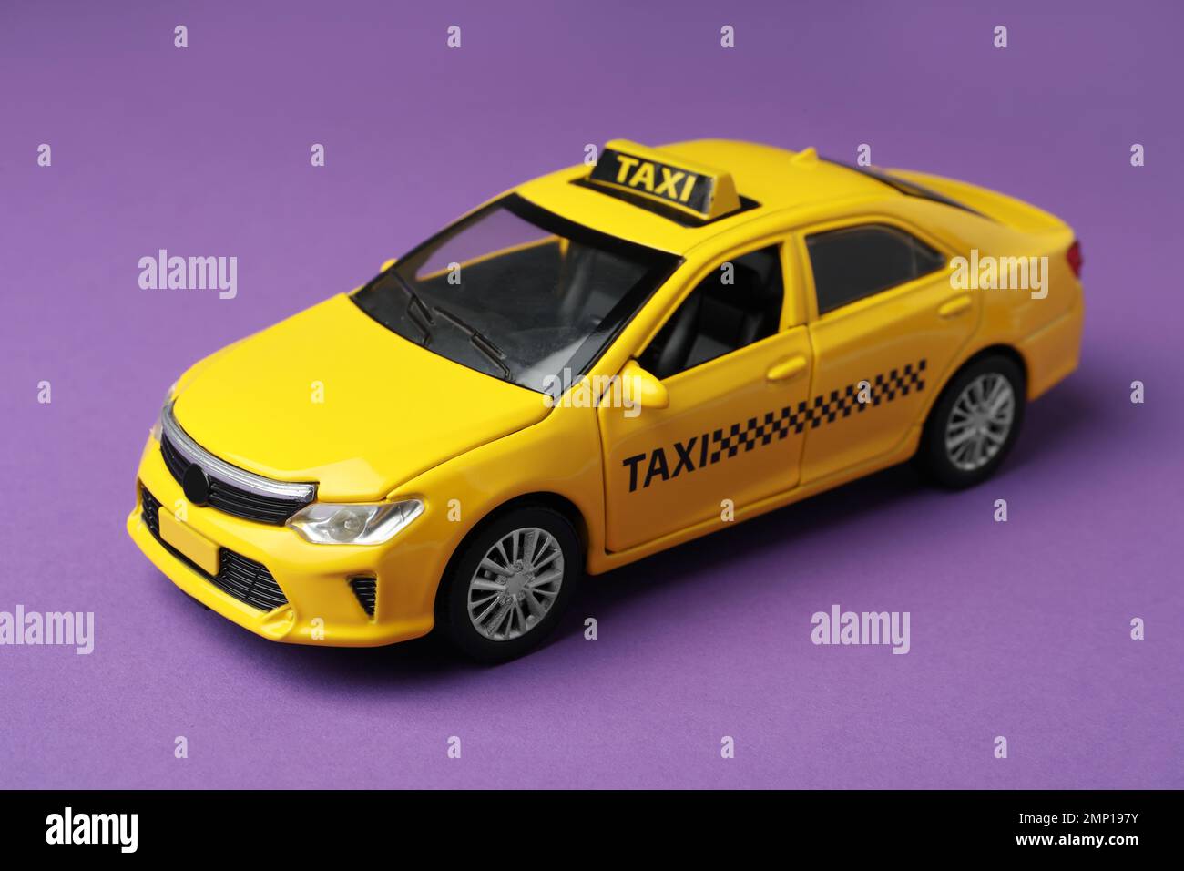 Yellow taxi car model on purple background Stock Photo - Alamy