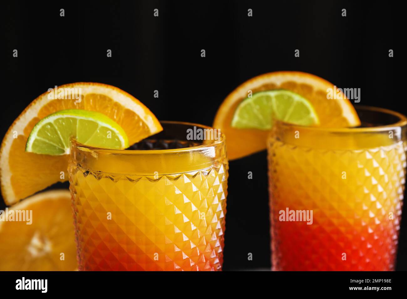 Fresh alcoholic Tequila Sunrise cocktails on dark background, closeup ...