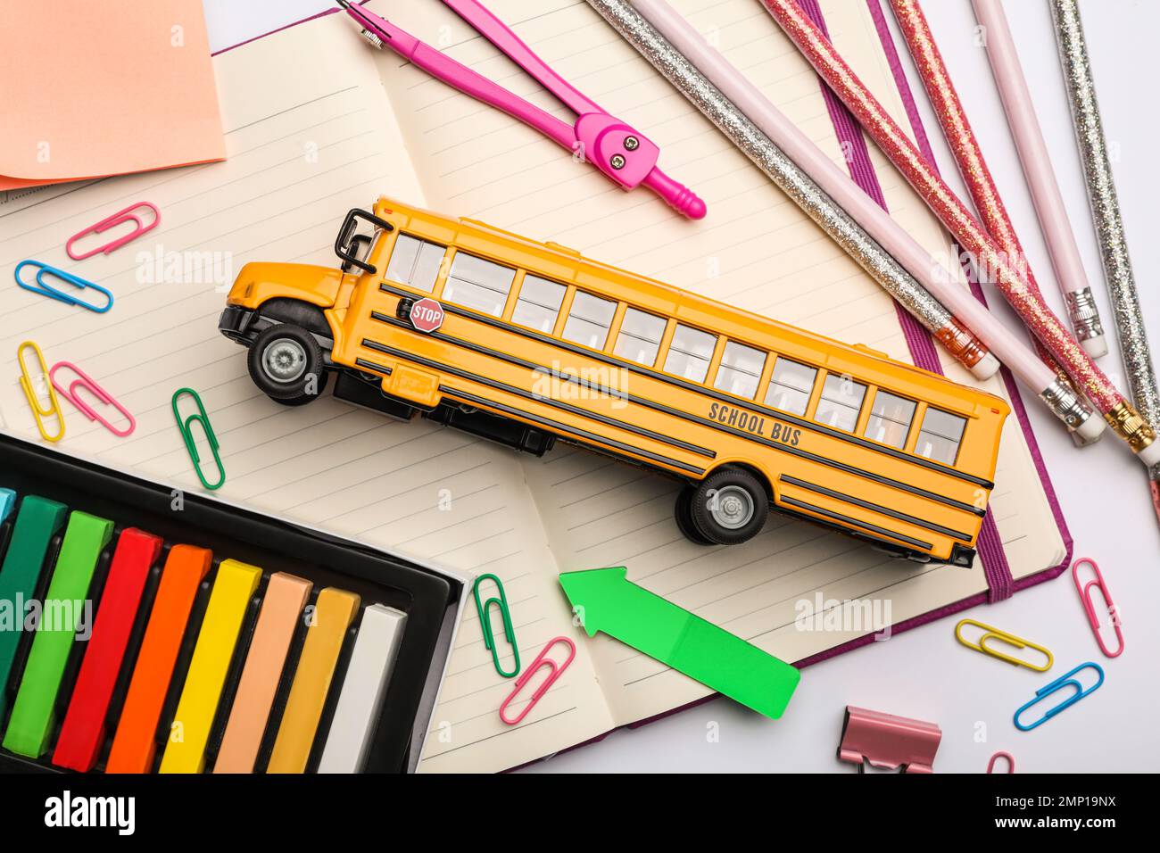 Flat lay composition with yellow school bus model on white background ...