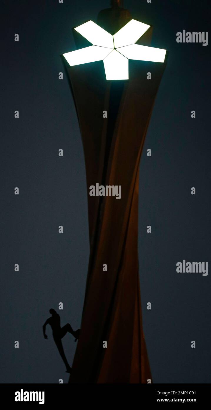 A human figure appears to be climbing an Olympic Cauldron at the ...