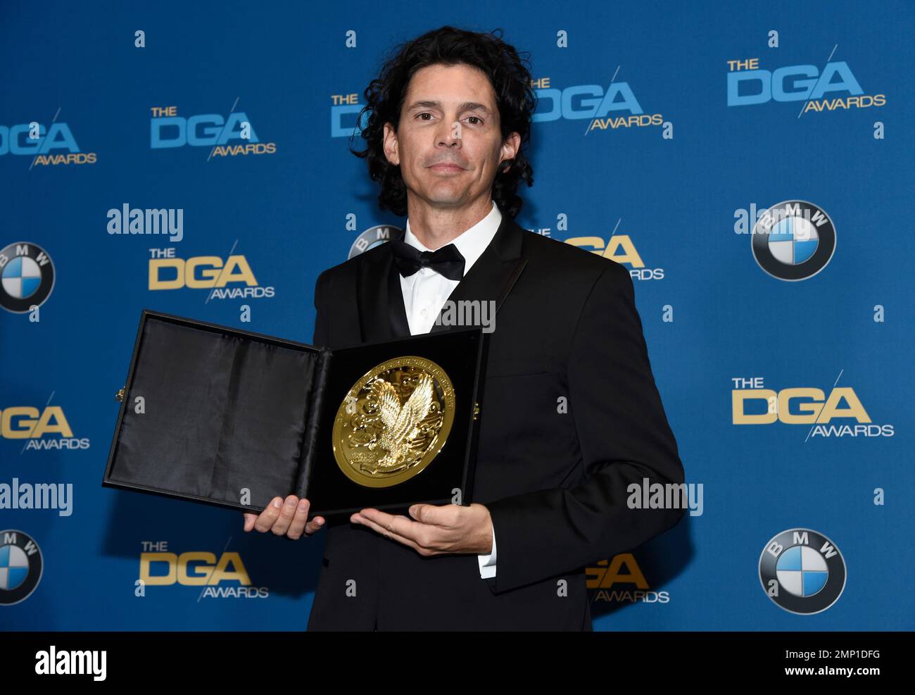 Brian Smith poses in the press room with the award for outstanding ...