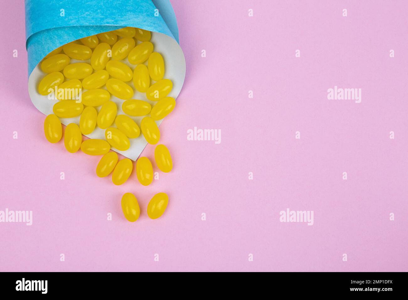 Delicious lemon jelly beans on pink background, top view. Space for ...