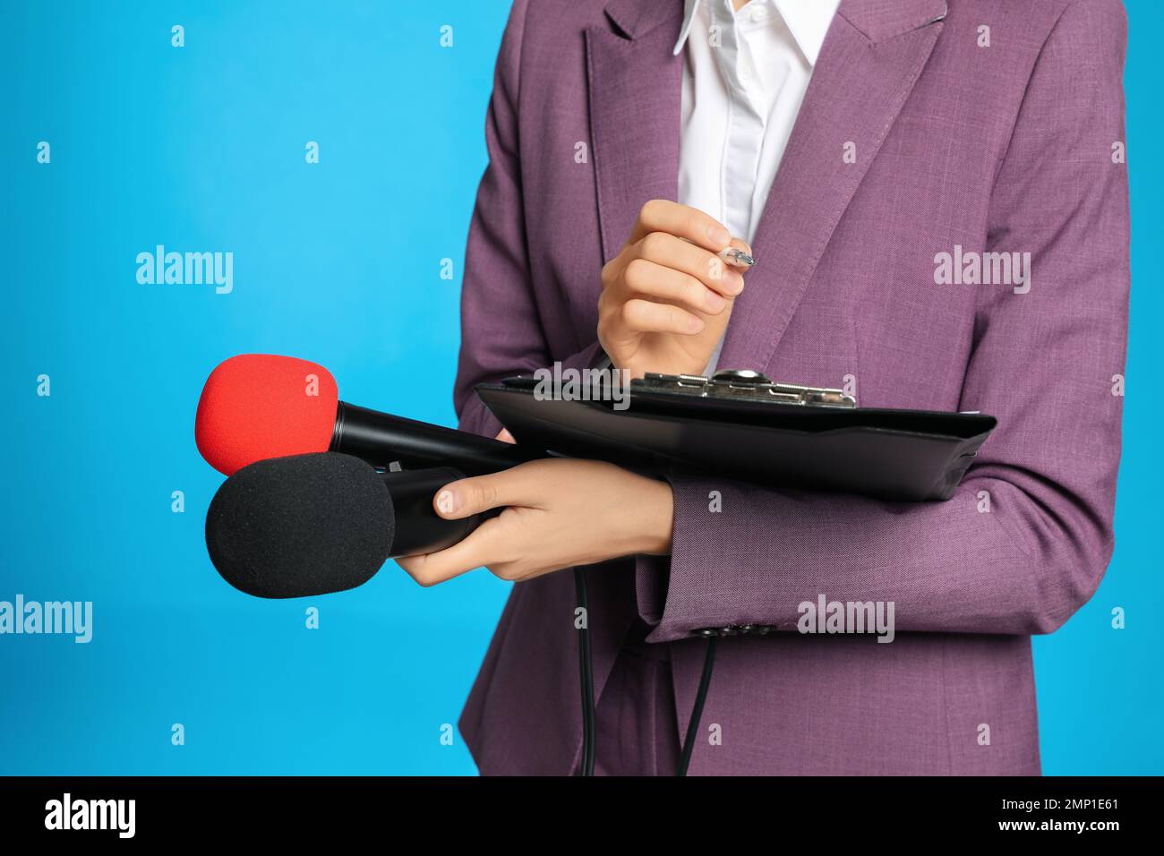 Professional journalist taking notes on light blue background, closeup ...
