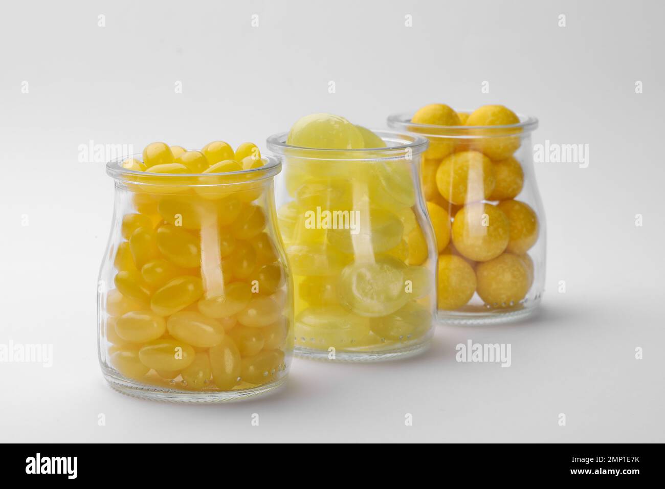 Different tasty lemon drops in jars isolated on white Stock Photo - Alamy