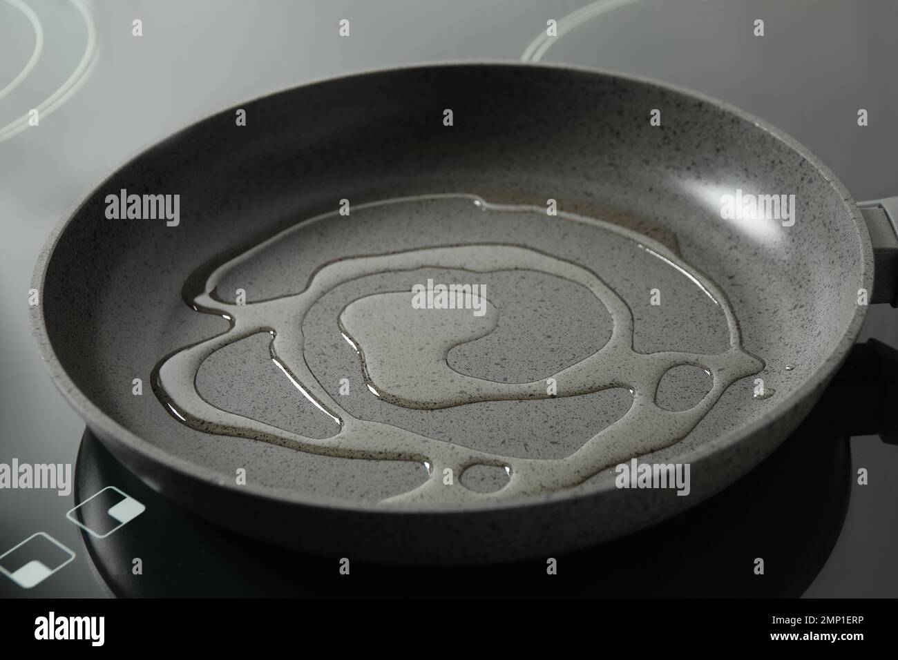 Frying pan with cooking oil on induction stove Stock Photo - Alamy