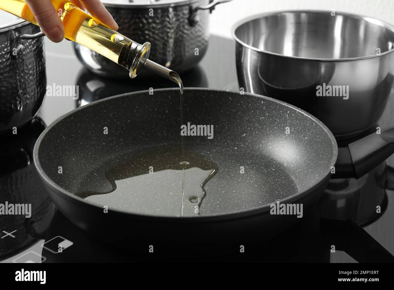 Woman pouring cooking oil from bottle into frying pan, closeup Stock ...