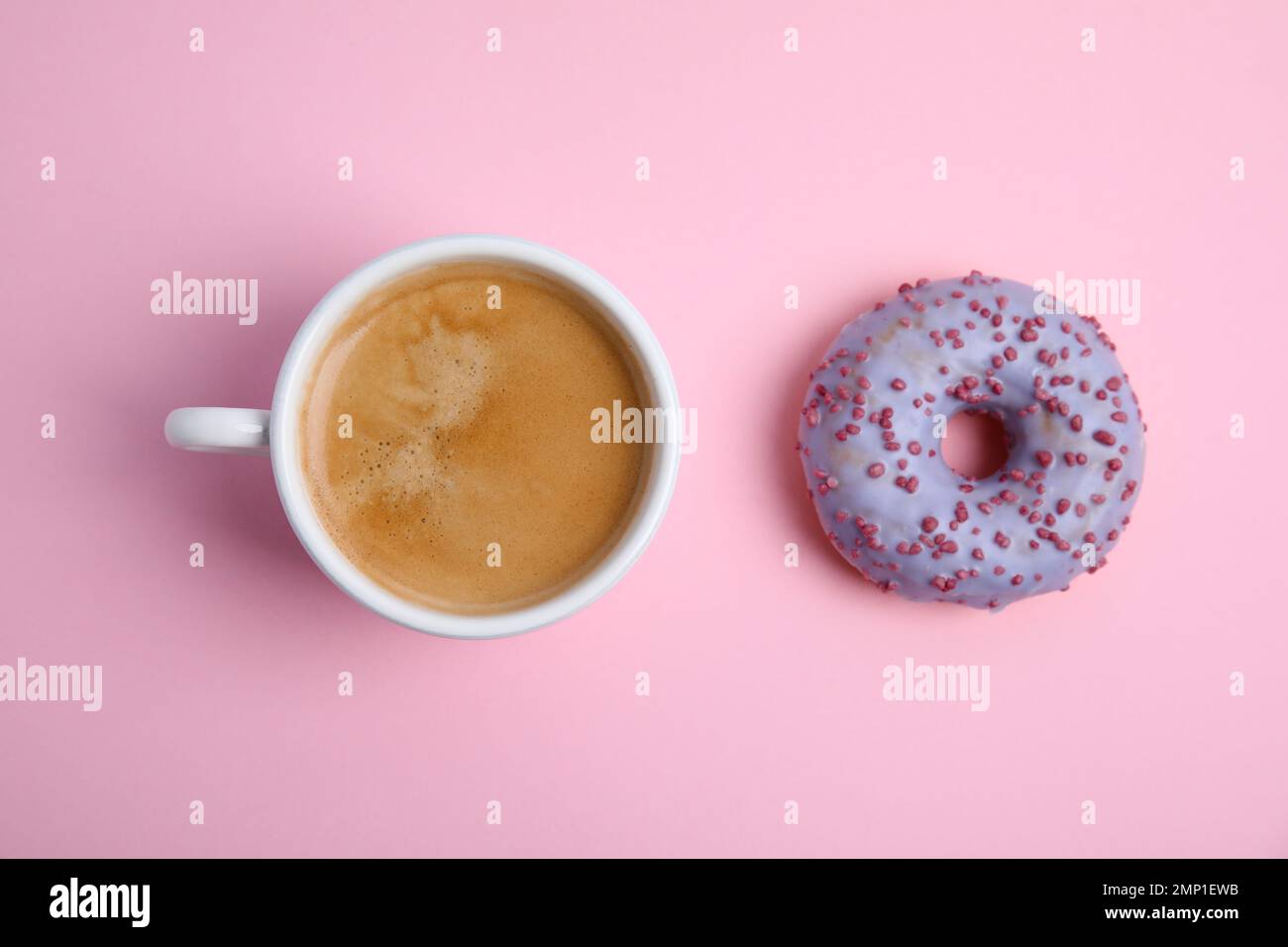 Delicious coffee and donut on light pink background, flat lay. Sweet ...