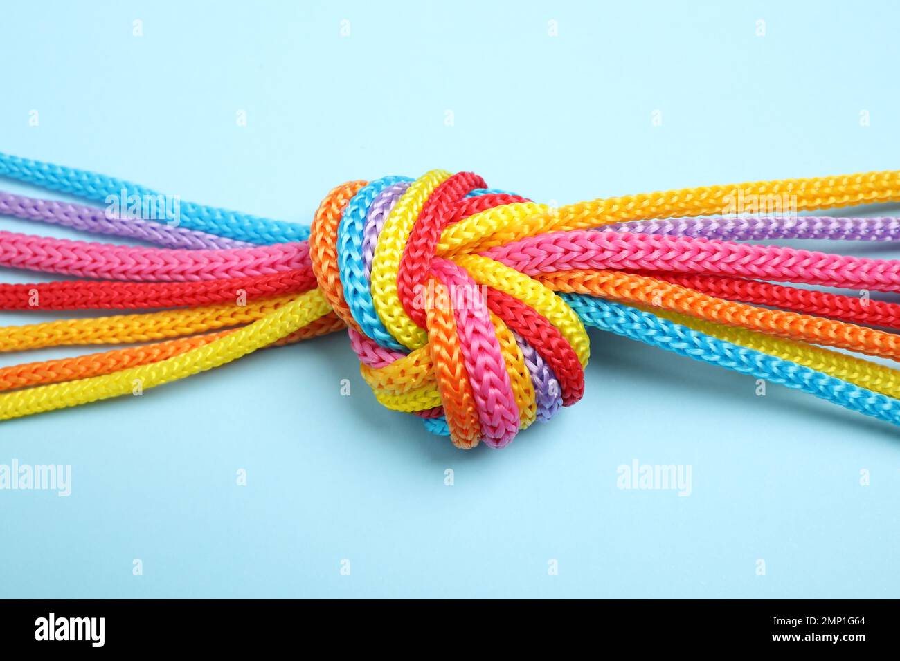 Colorful ropes tied together on light blue background, top view. Unity ...