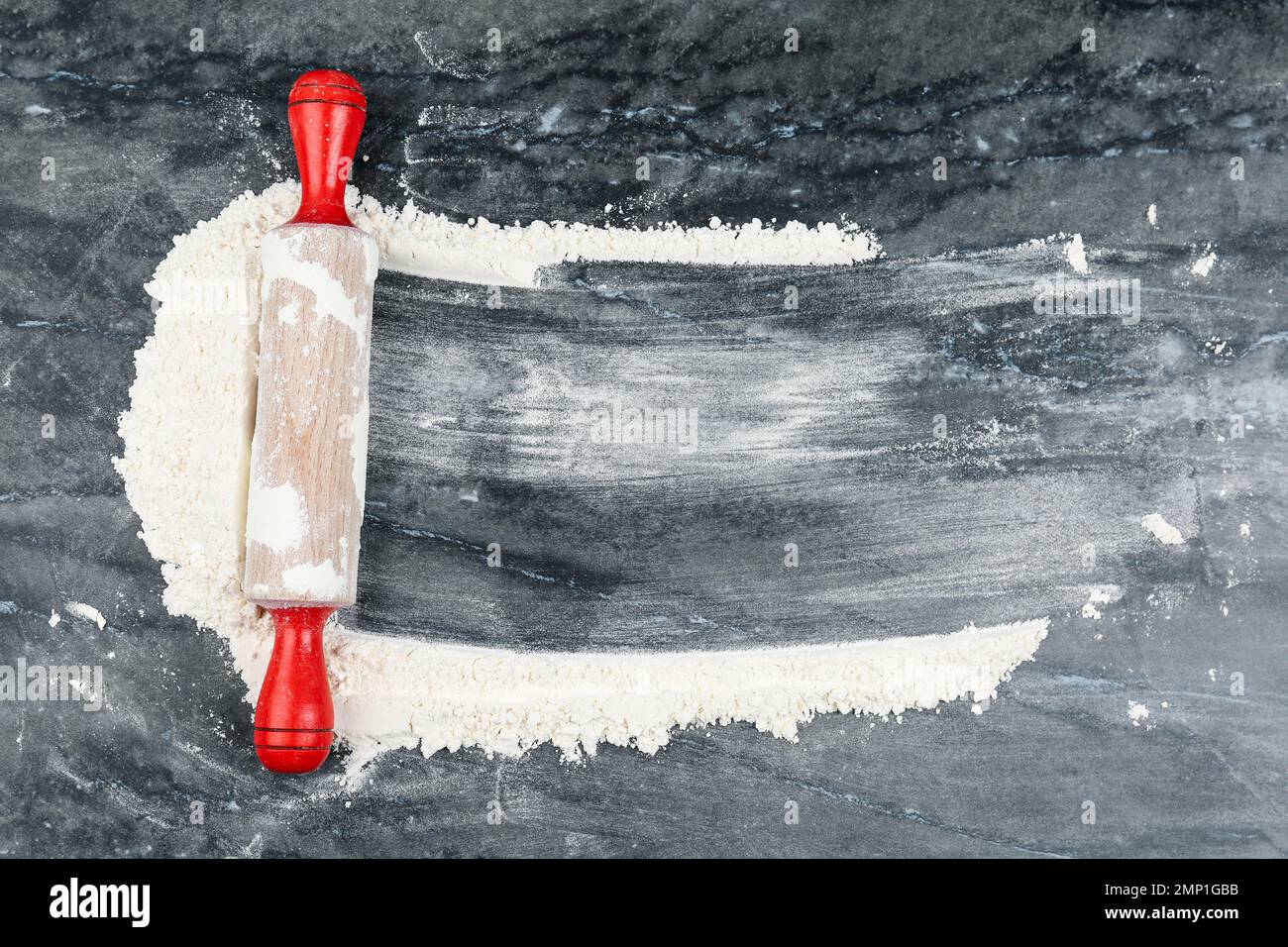 Flour and rolling pin on grey marble table, top view. Space for text ...