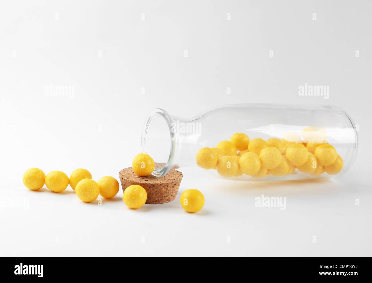 Tasty lemon drops and bottle on white background Stock Photo - Alamy