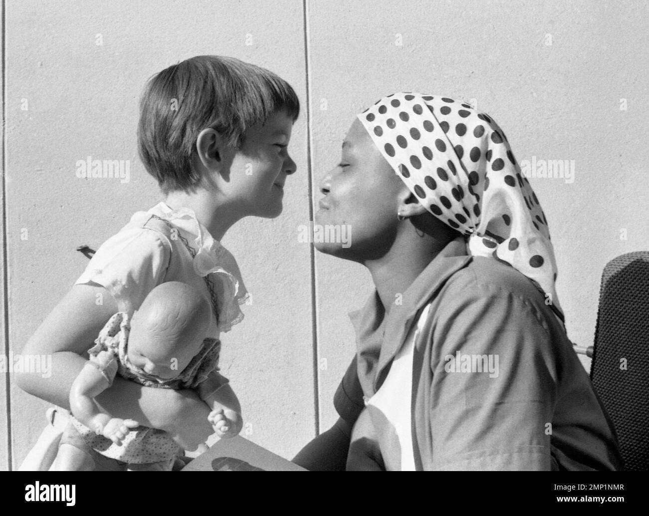 A white South African child smiles with her black nanny in Johannesburg ...