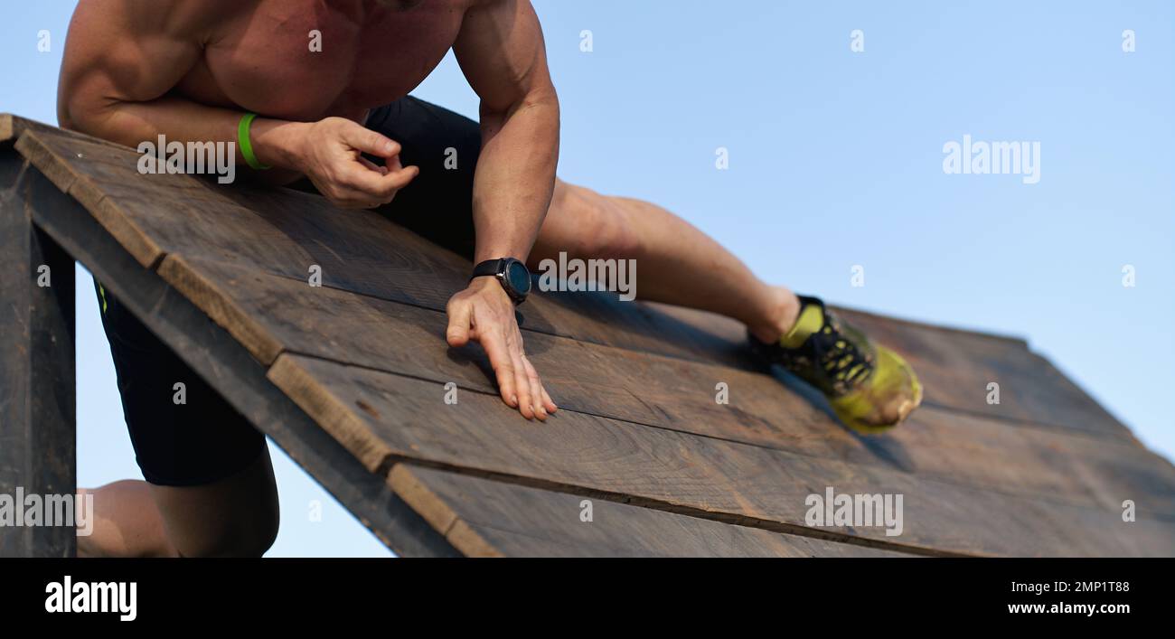 Mud race runners running over obstacles extreme sport Stock Photo - Alamy