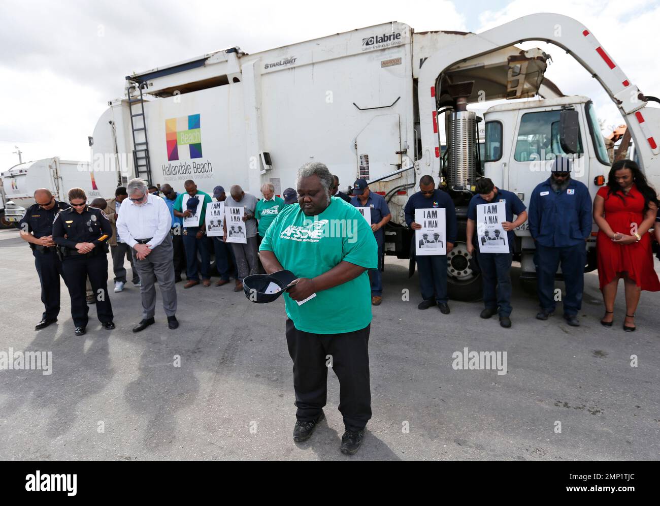 Milton Harmon Sr., foreground, leads city officials and workers ...
