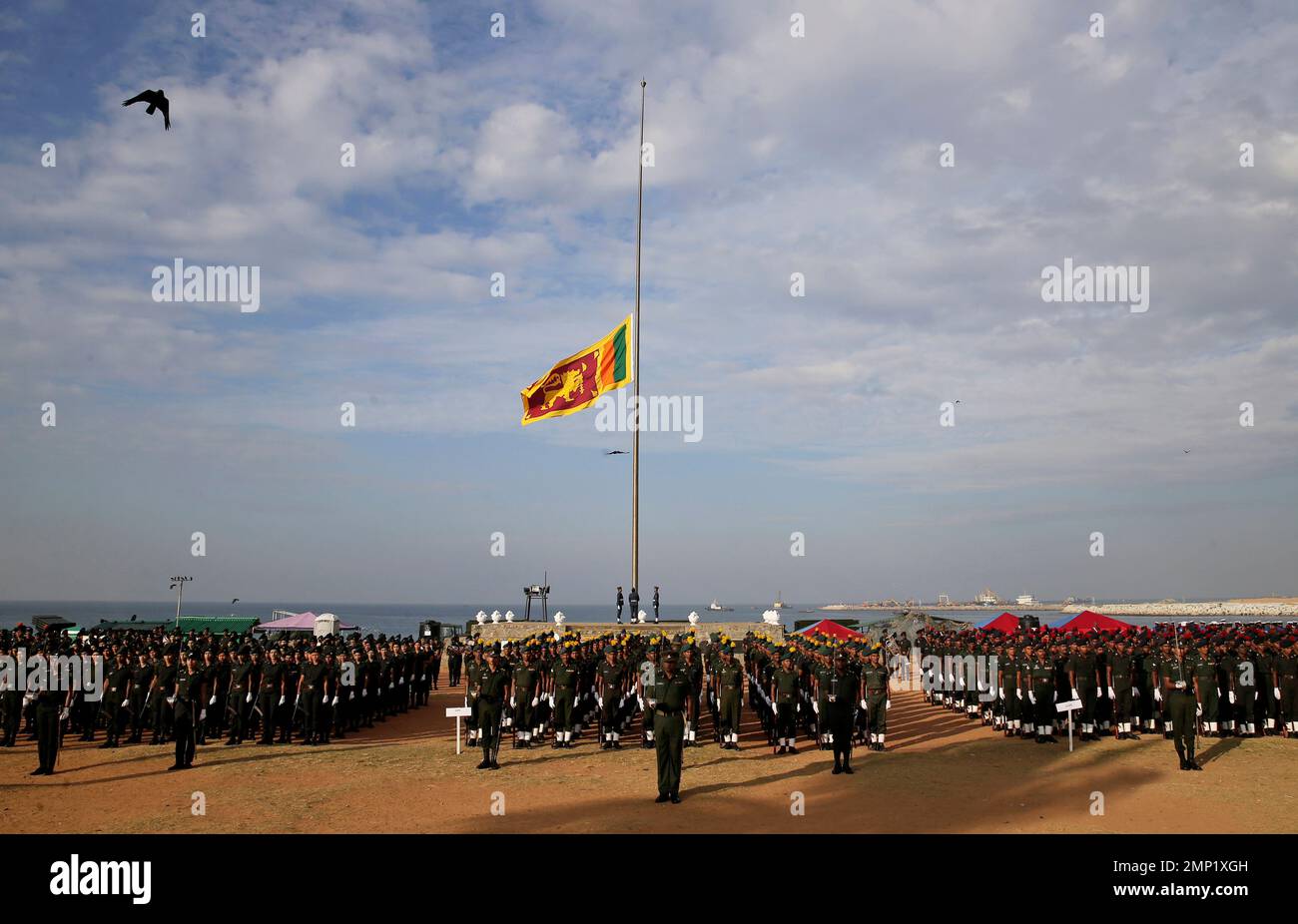 Sri Lankan army soldiers hoist their national flag as others stand in a ...