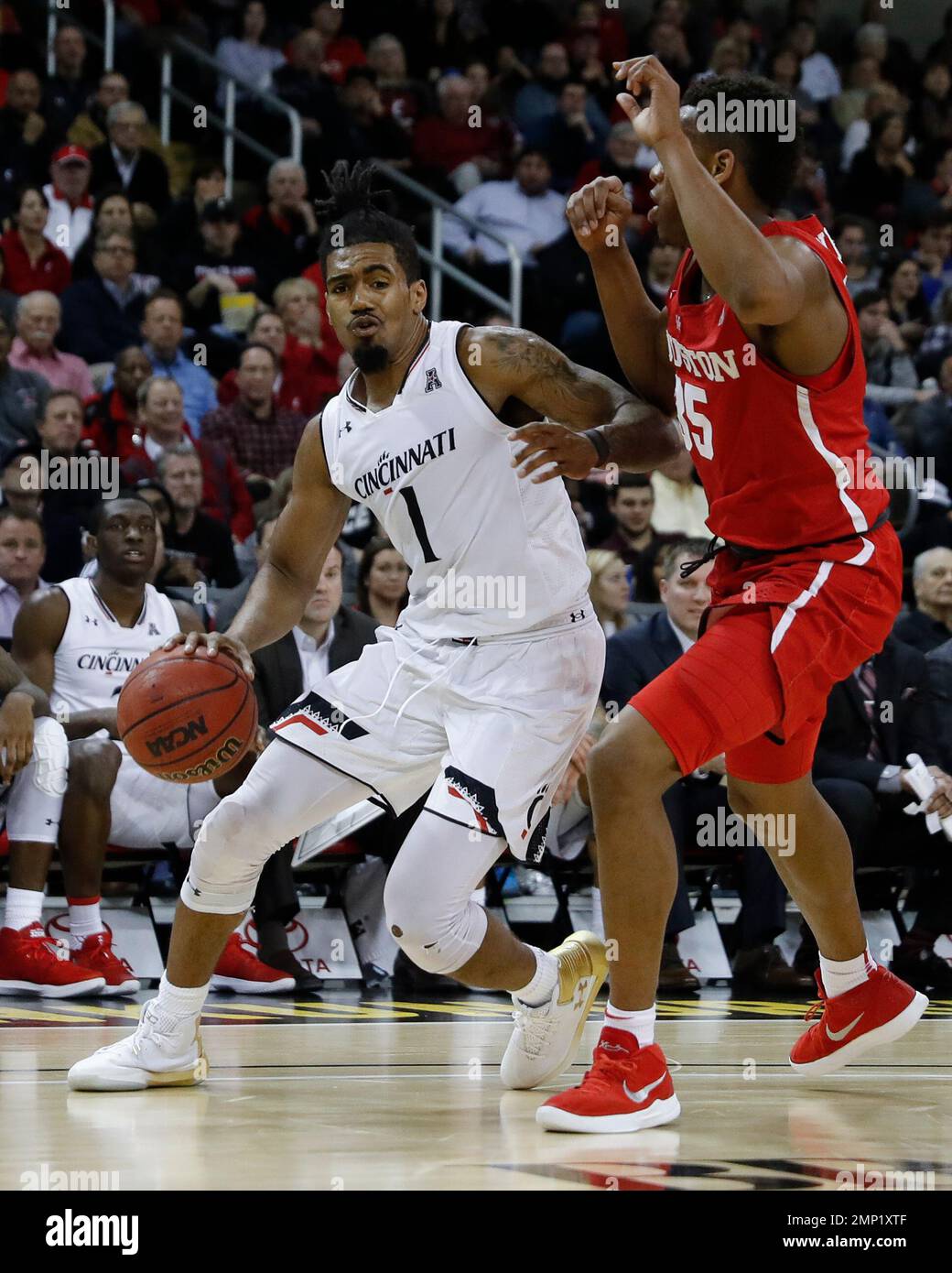 Cincinnati's Jacob Evans (1) drives around Houston's Devin Davis (15 ...