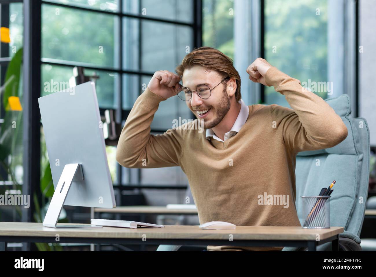 Young man in office celebrating victory and successful achievement ...