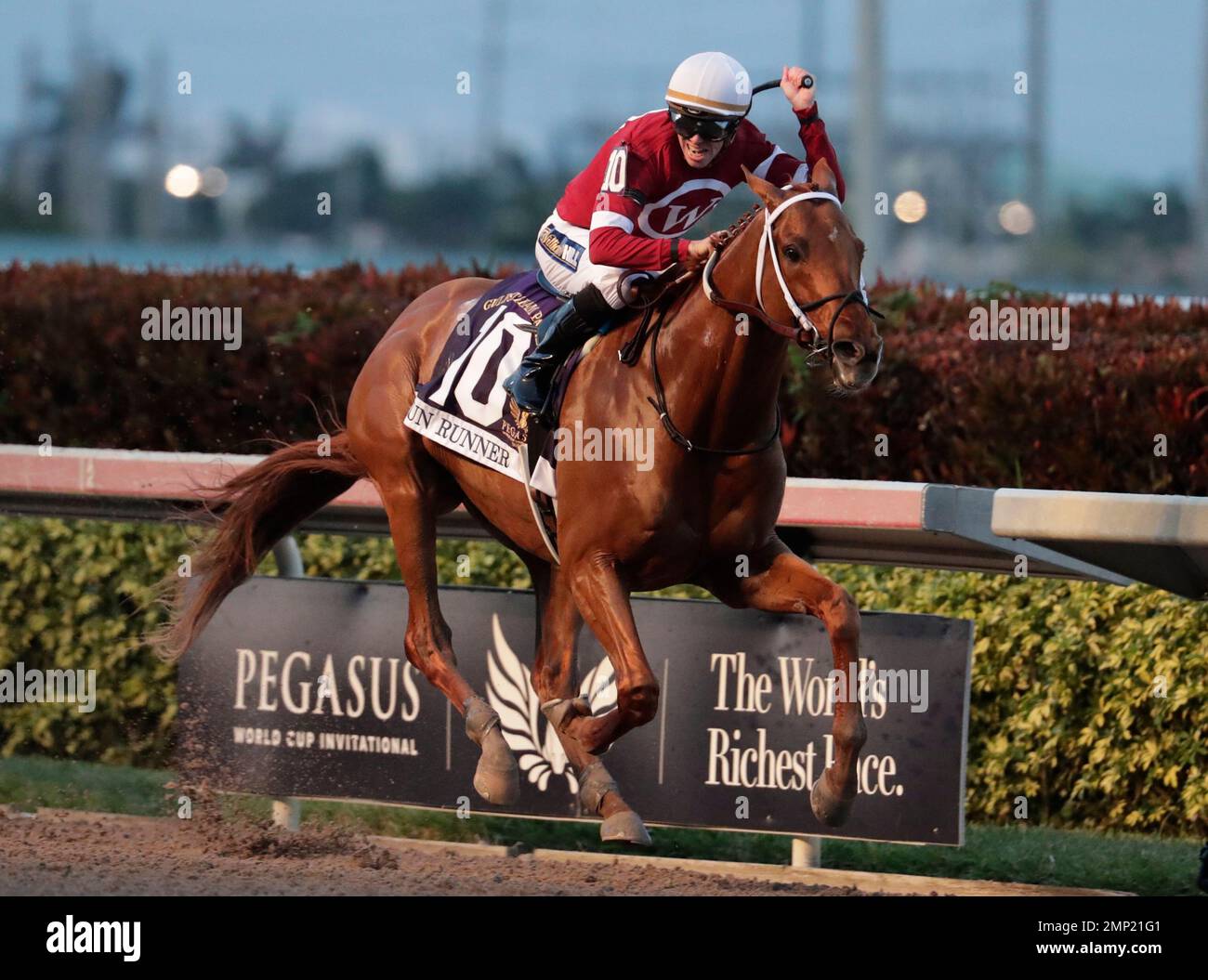 Jockey Florent Geroux rides Gun Runner (10) past the finish line to win ...