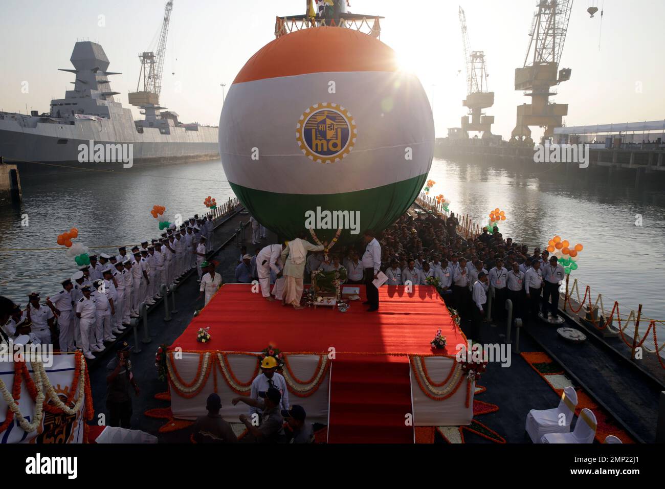 A priest offers prayers as personnel of the Indian Navy look on before ...