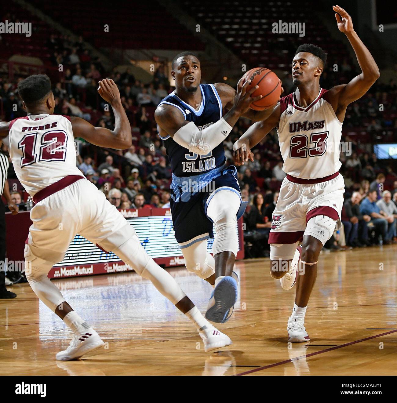 Rhode Island's Jared Terrell, center, splits the defense of ...
