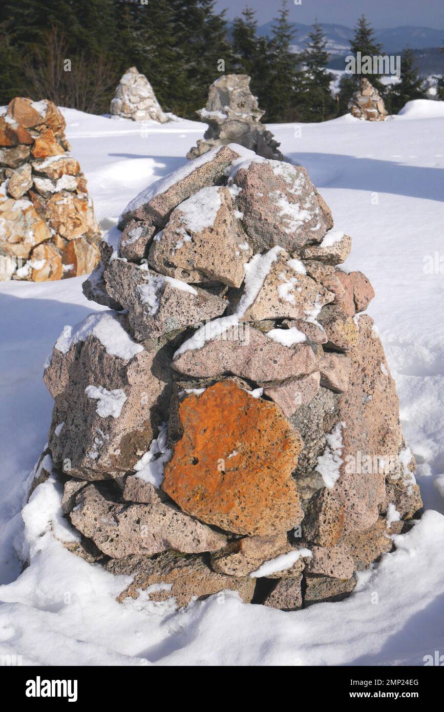 Cairns in winter along a hiking trail in the Banska Stiavnica Geopark ...