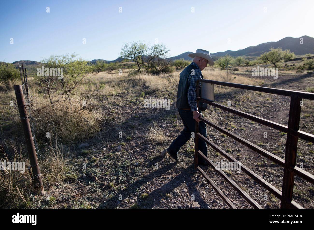 Rancher Jim Chilton opens a gate on his 50,000-acre ranch along the US ...