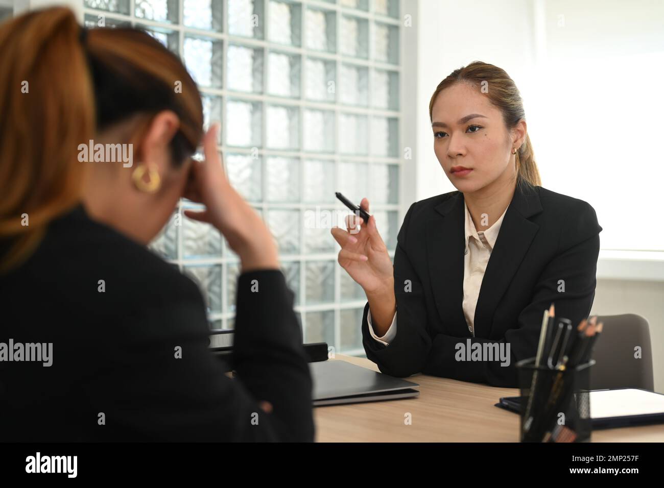 Furious female manager scolding young frustrated young employee with ...