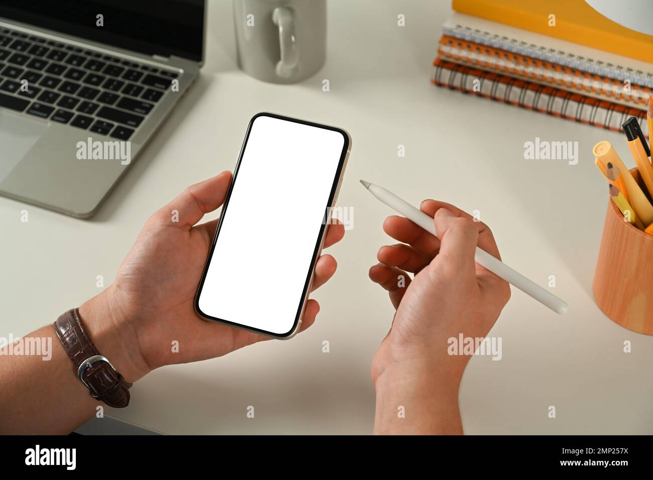 Close up view of man hand holding stylus pen and using smart phone over ...