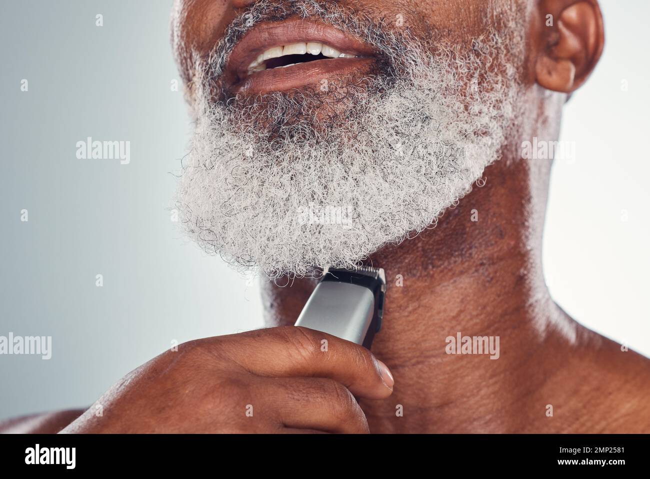 Grooming, skincare and man shaving beard on face isolated on a grey studio background. Cleaning ...