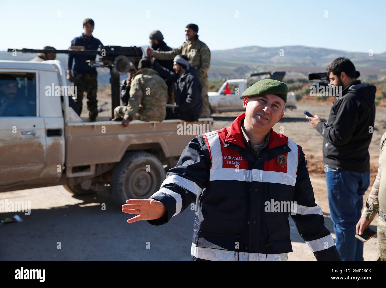 A Turkish police officer tries to stop members of the media from ...