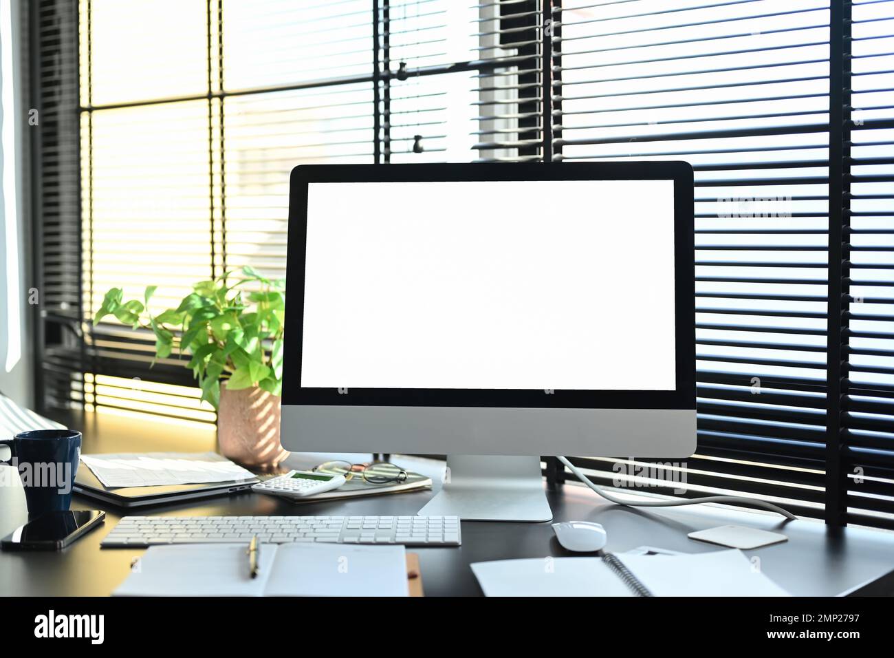 Modern corporate office interior with blank computer monitor, documents ...