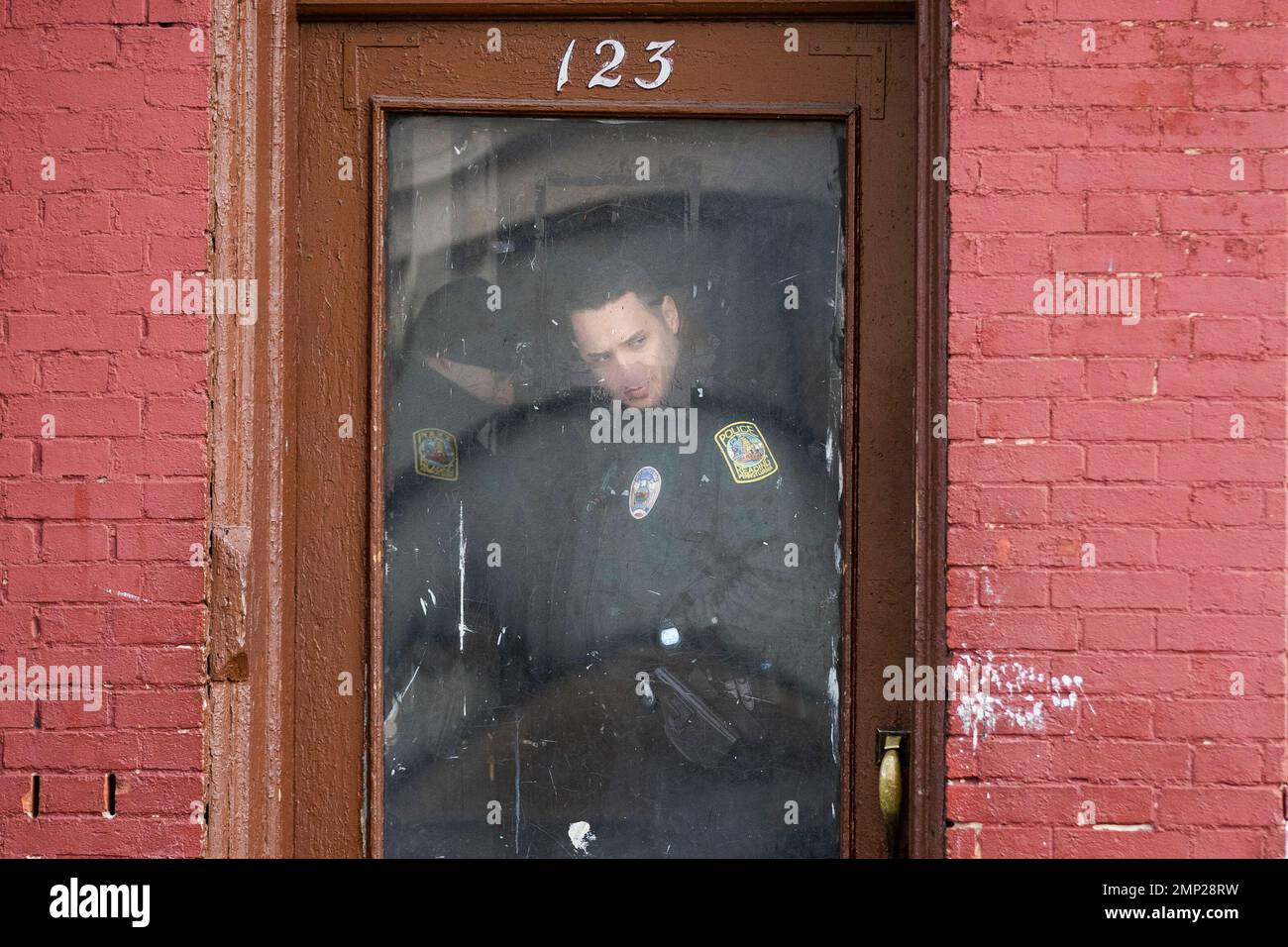 An officer looks out from a row home where authorities say at least ...