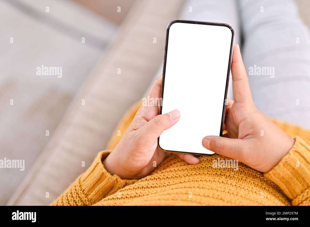 Top view of a woman using her smartphone on sofa in the living room ...