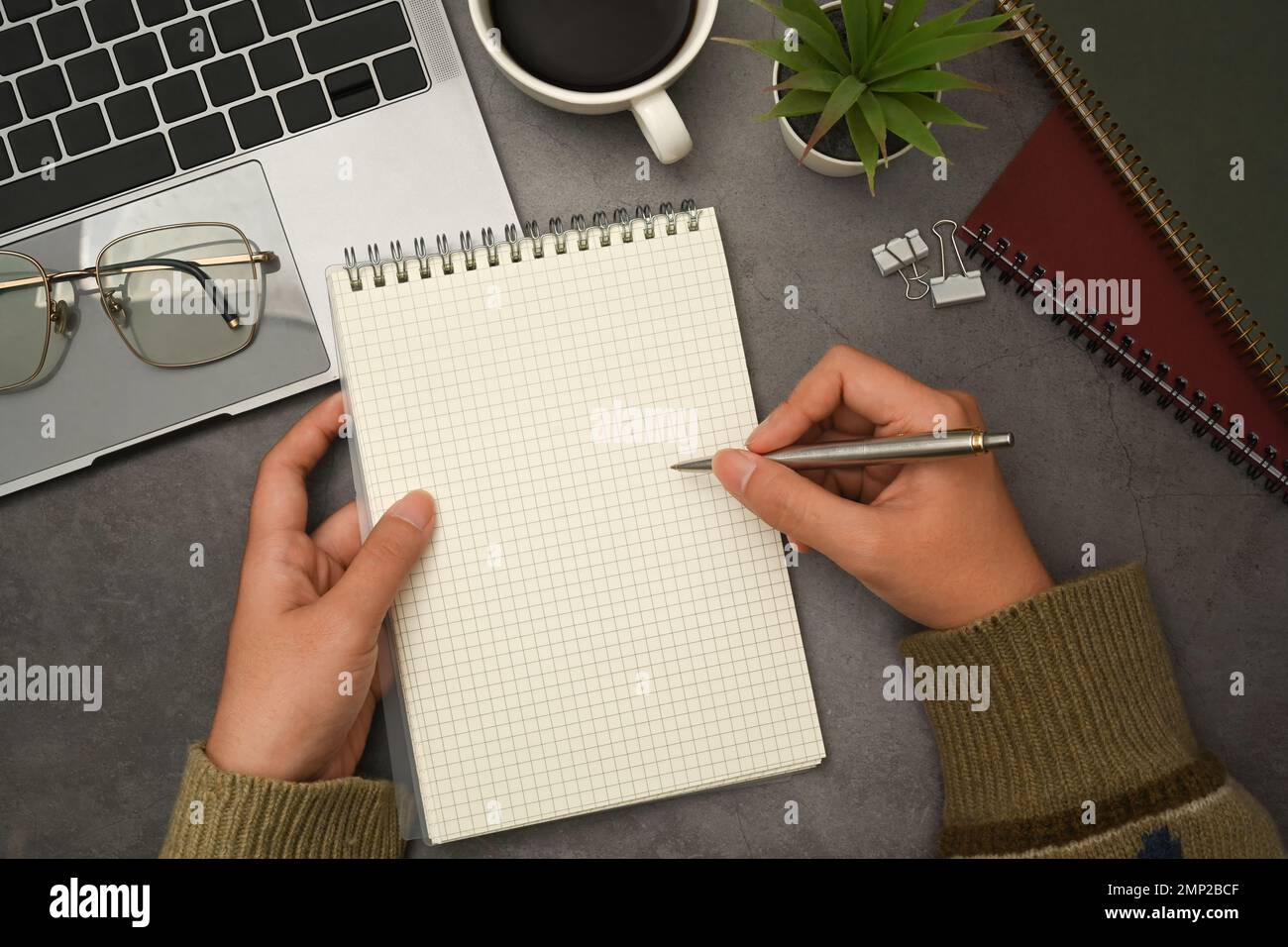 Close up view of creative woman hand holding blank notepad and pen over ...