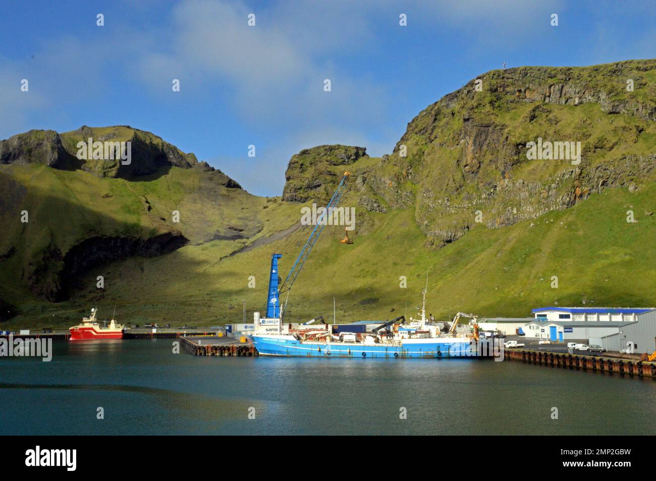 Iceland, Island of Heimaey: towering cliffs protect the harbour from ...