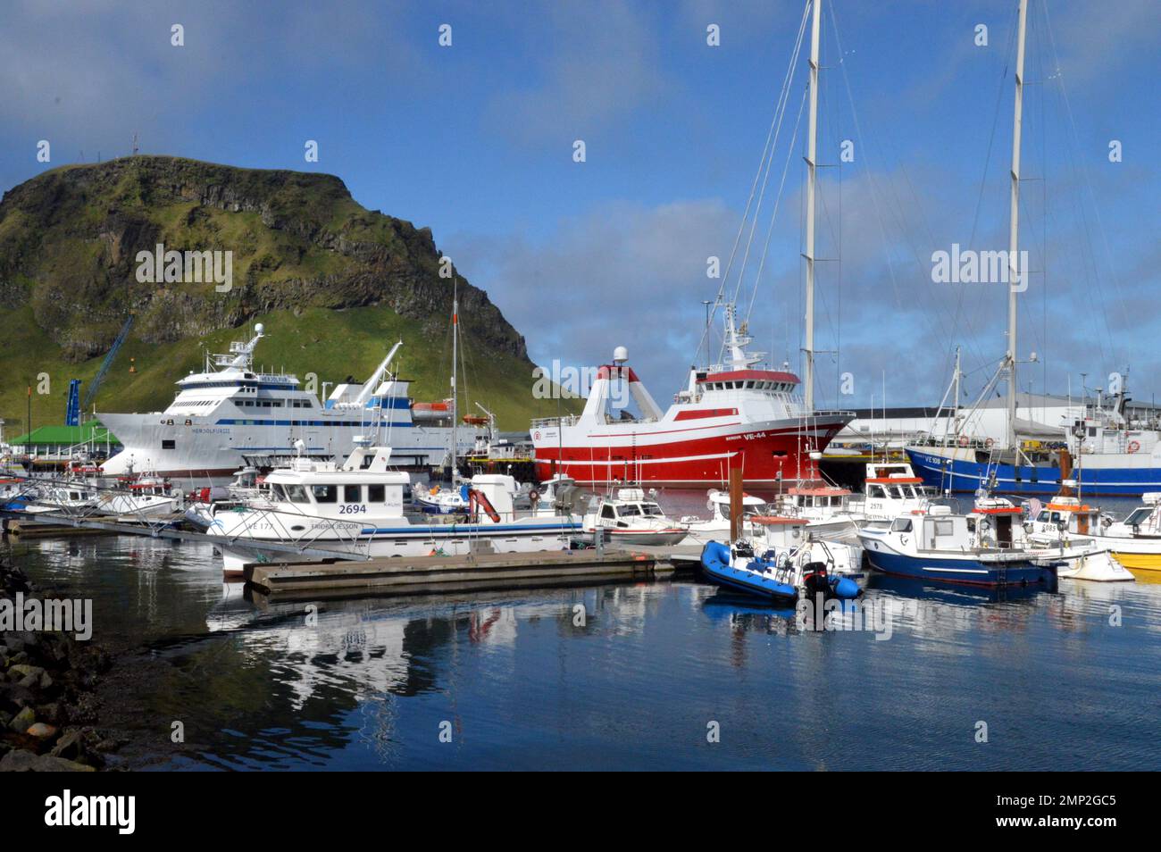 Iceland, Island of Heimaey: a colourful assortment of vessels reflected ...