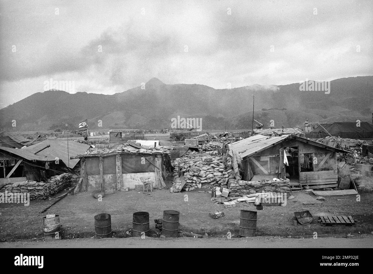 A U.S. Marine, center, stands atop sandbags that protect the tin-roofed ...