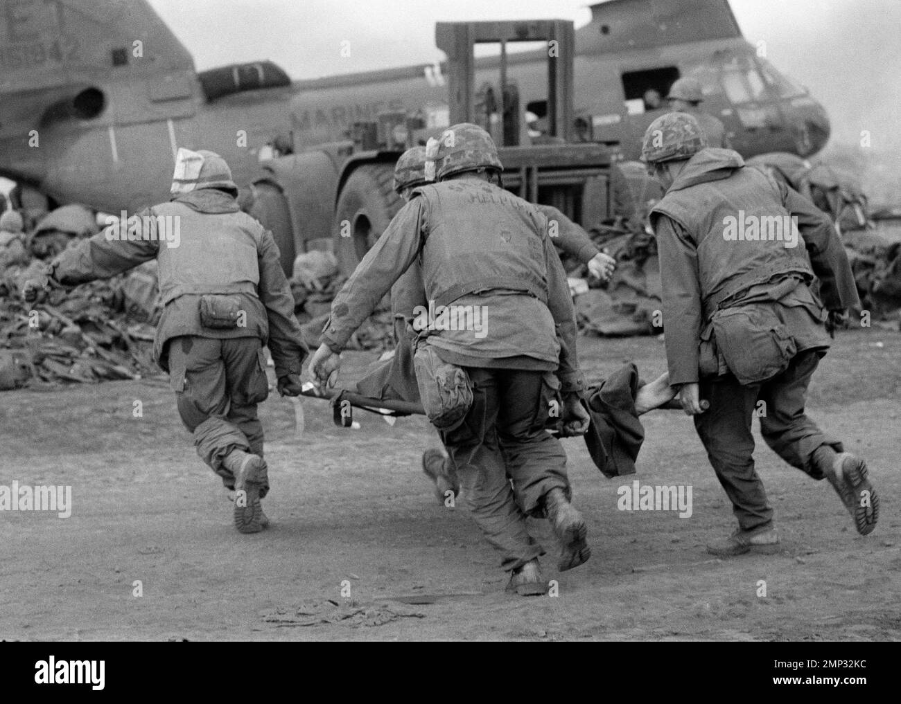 U.S. Marines at Khe Sanh carry a comrade, wounded in Communist shelling ...