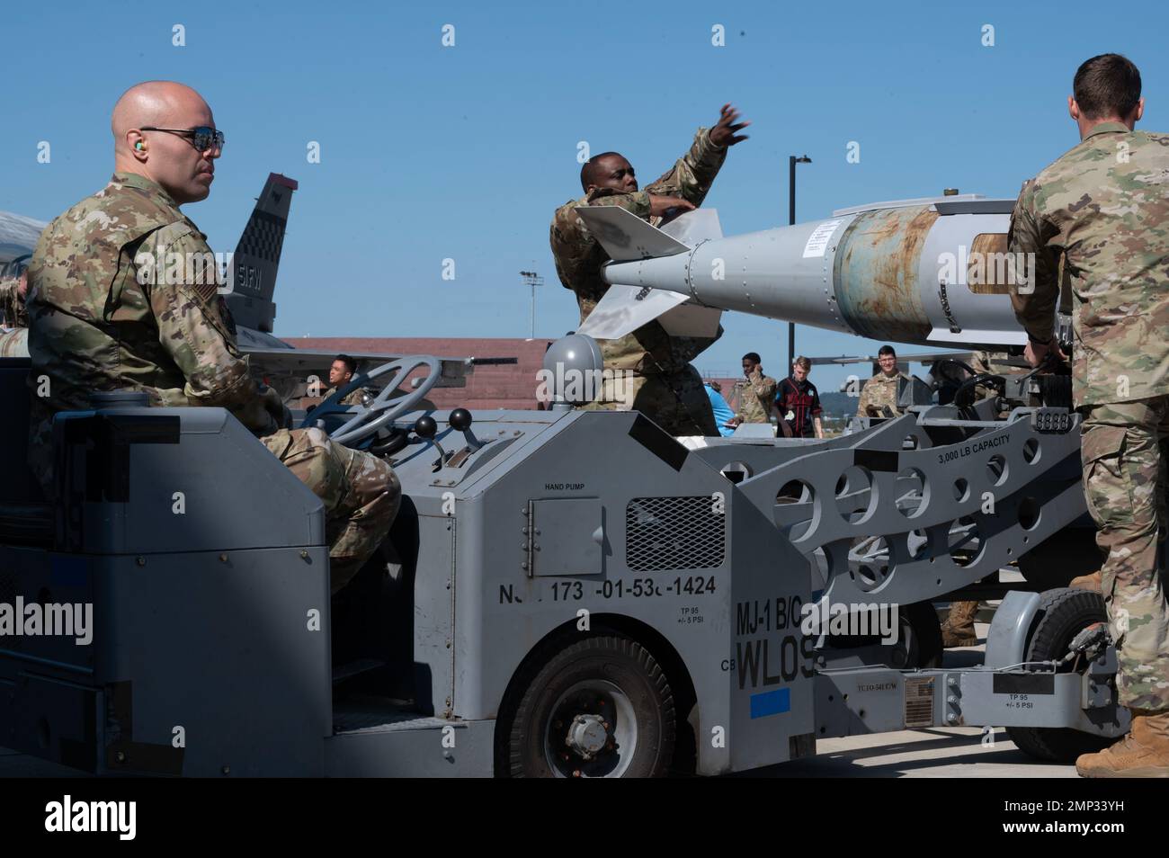U.S. Air Force Airmen, assigned to the 51st Munitions Squadron, move a ...