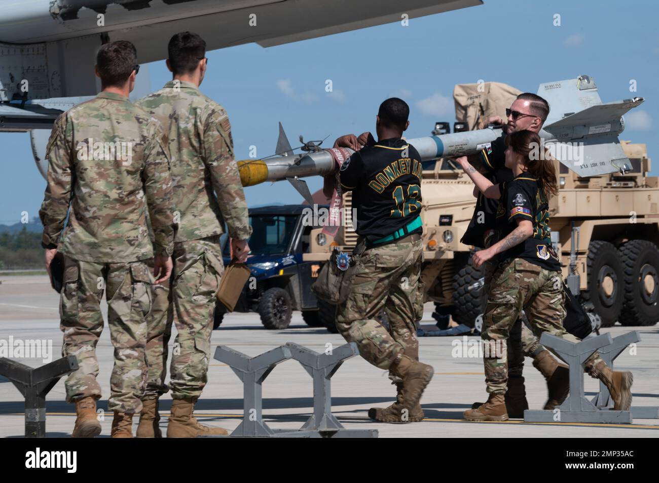 U.S. Air Force weapons load crew members, assigned to the 25th Fighter ...