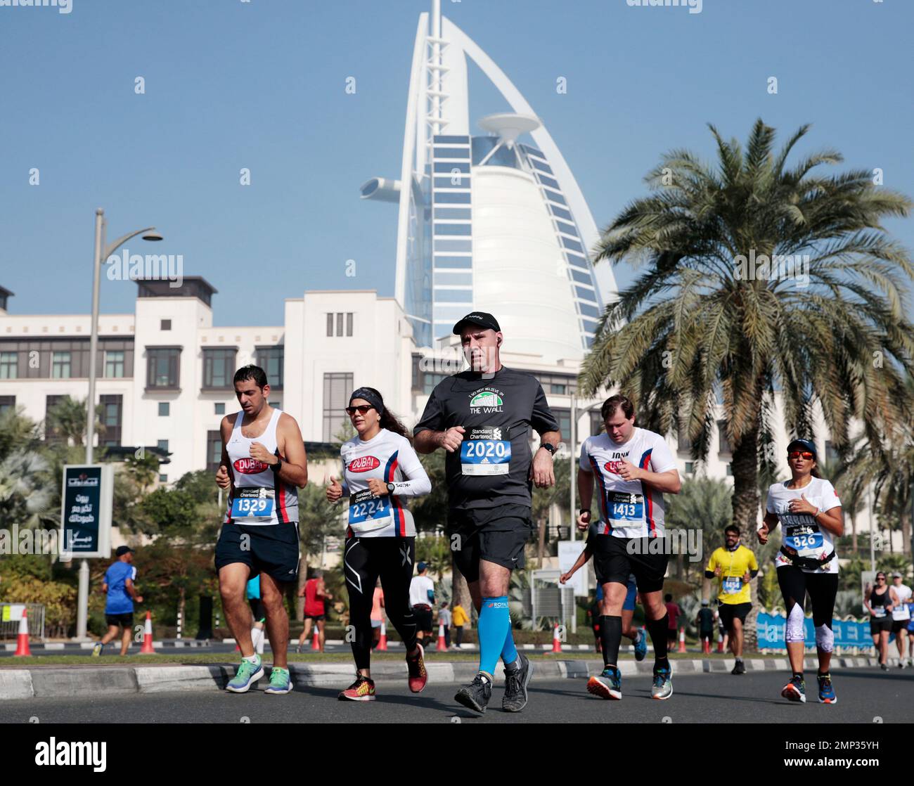 Runners pass the Burj Al Arab hotel during the Standard Chartered Dubai ...