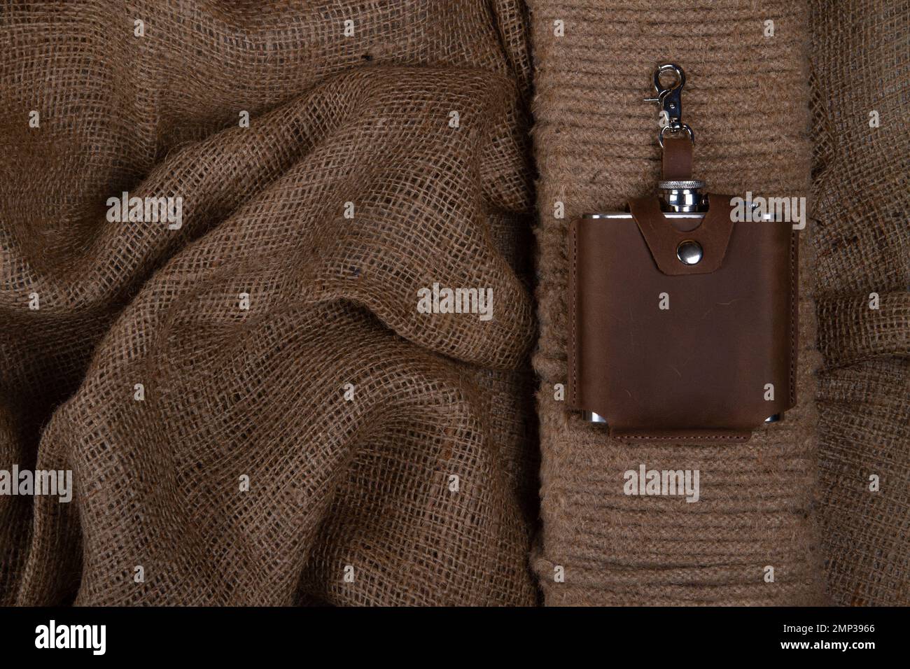Hip flask in leather Hip flask case on sack cloth background Stock ...
