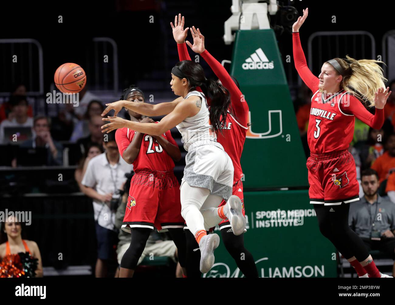Miami's Shaneese Bailey passes as Louisville's Jazmine Jones (23) and ...