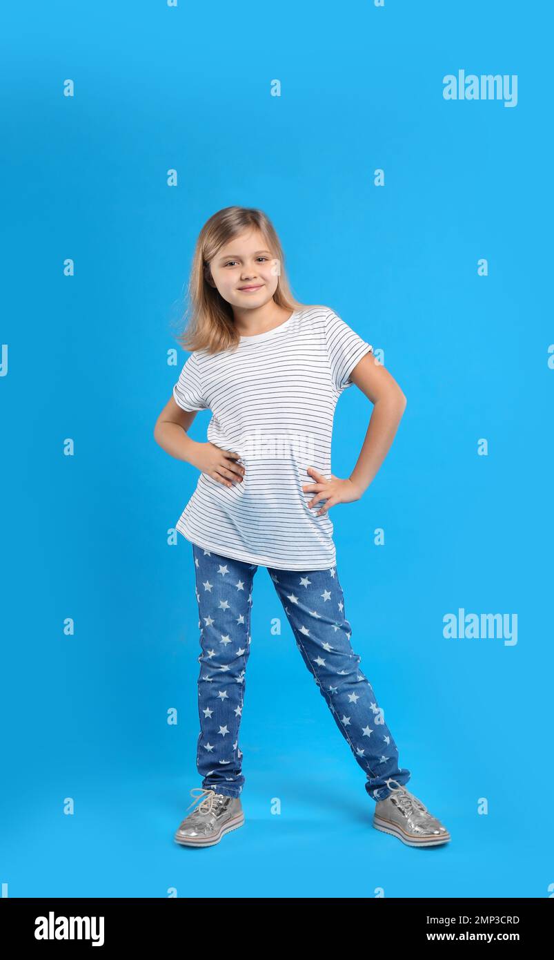 Cute little girl on light blue background Stock Photo - Alamy