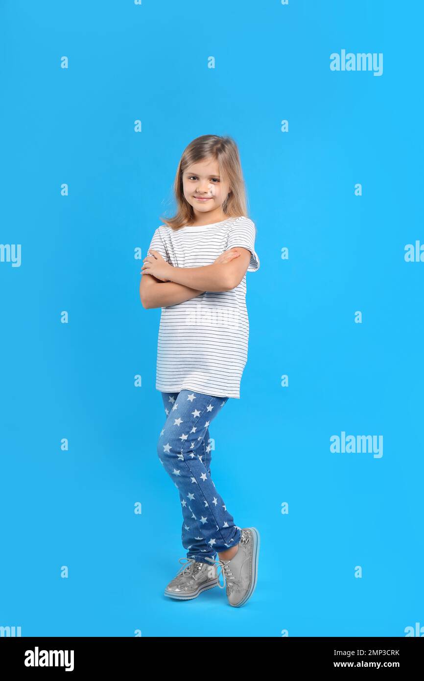 Cute little girl on light blue background Stock Photo - Alamy