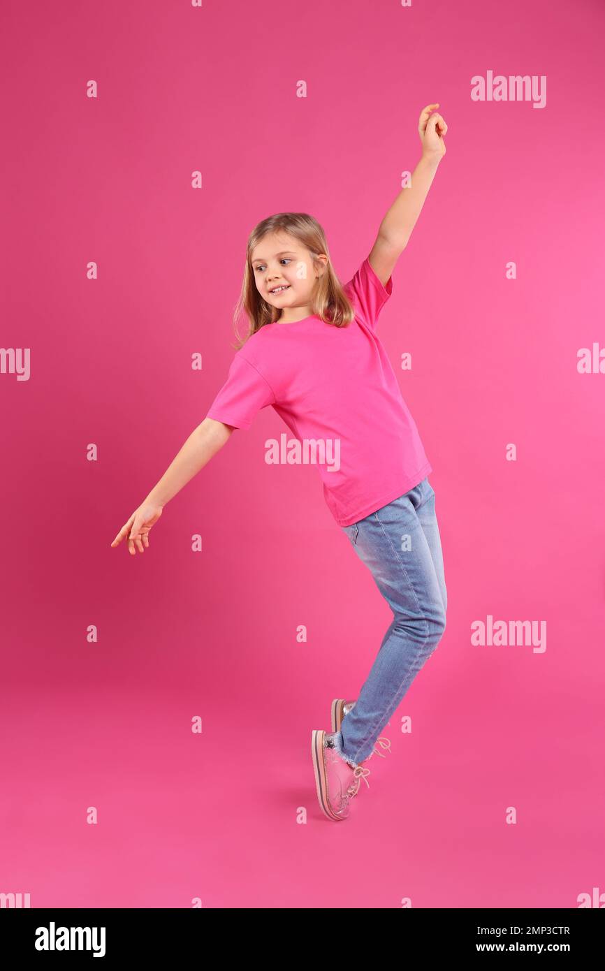 Cute little girl dancing on pink background Stock Photo - Alamy