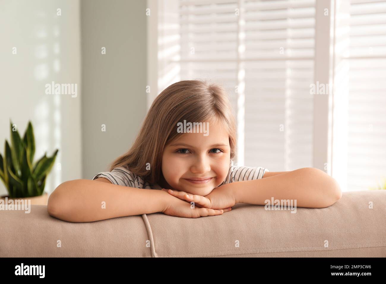 Cute little girl on couch at home Stock Photo - Alamy