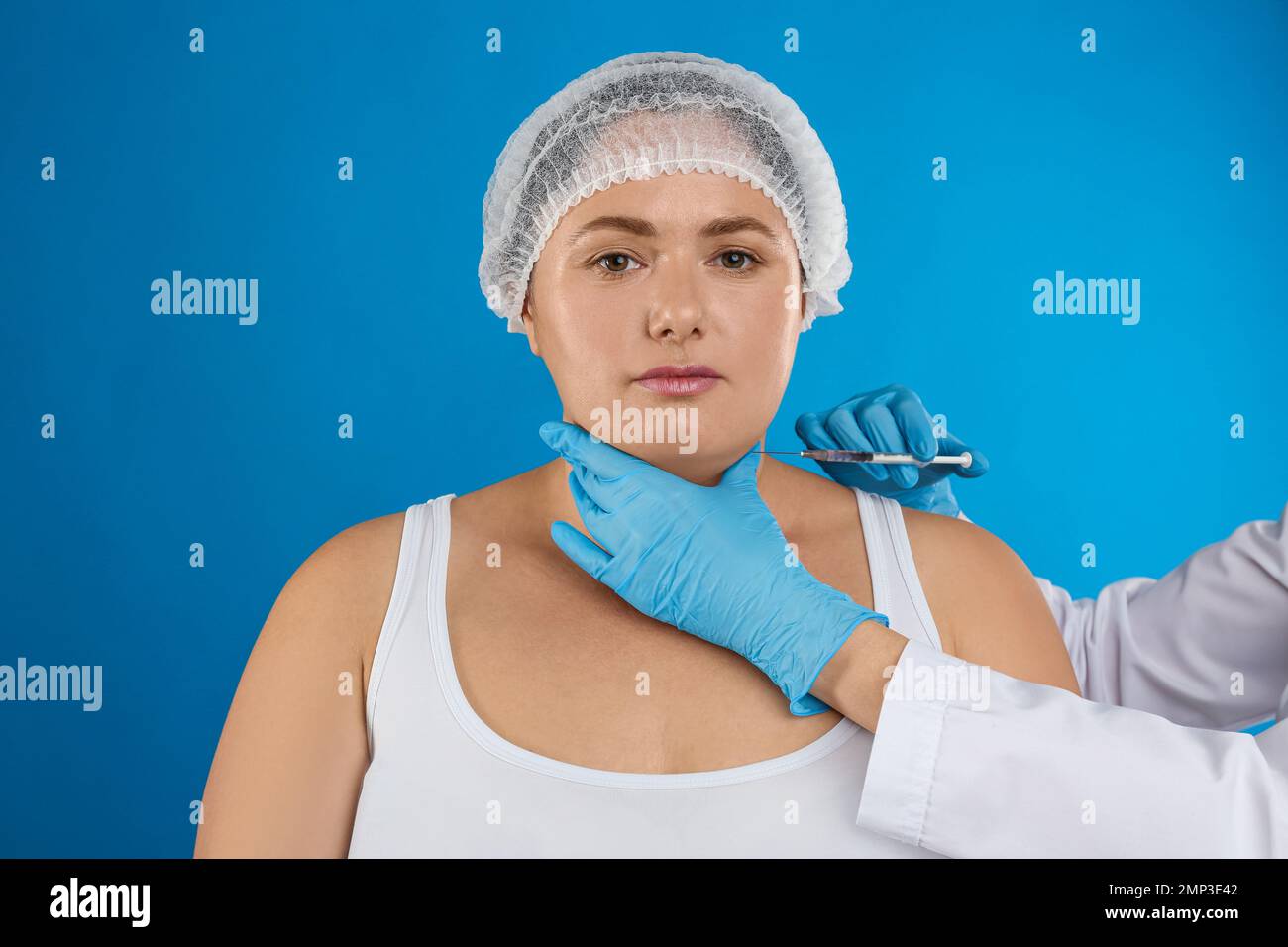 Woman with double chin getting injection on blue background. Cosmetic ...