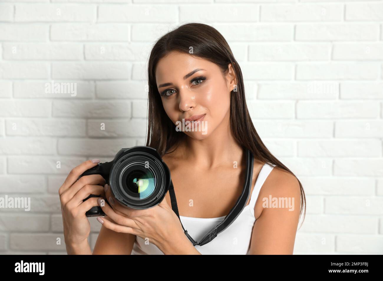Professional photographer working near white brick wall in studio Stock ...