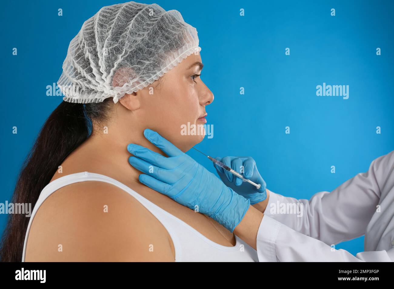 Woman with double chin getting injection on blue background. Cosmetic ...