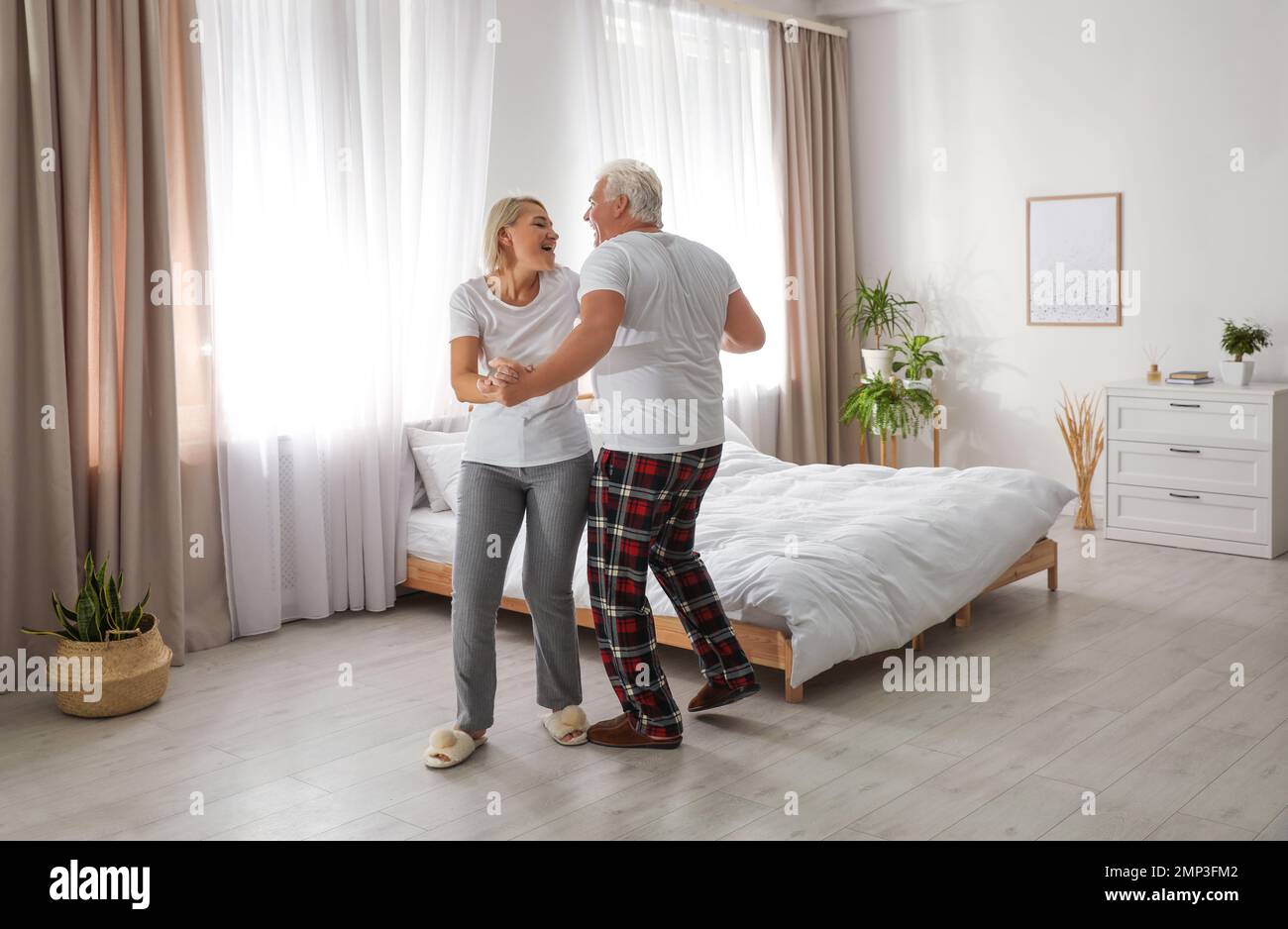 Happy mature couple dancing together in bedroom Stock Photo - Alamy